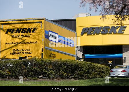 A logo sign and rental trucks outside of a facility occupied by Penske ...