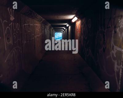Underground room with bright light shining at the end of the staircase ...
