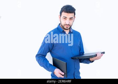 Arab man with beard holding laptop jumping against pink and purple ...