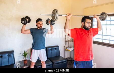 Two brothers weight lifting and doing sports together at home Stock ...