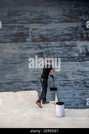 Construction site, application of a bituminous coating on a concrete ceiling, preparation for ...