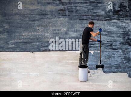 Construction site, application of a bituminous coating on a concrete ceiling, preparation for ...