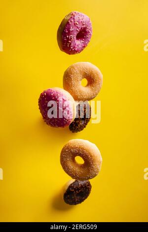 Falling doughnuts with multicolored glaze on trendy pink background ...