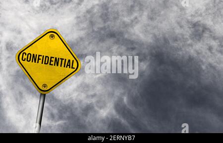Confidential - yellow sign with blue sky background Stock Photo - Alamy