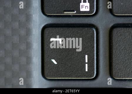 Grave accent, broken bar and negation symbol key on a laptop keyboard ...
