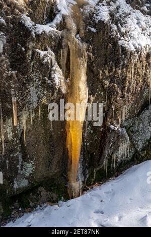 The brown colored icicles hanging from the rock Stock Photo - Alamy