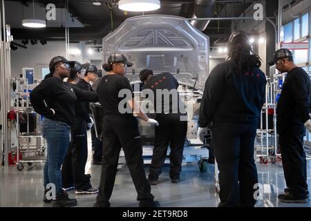 New Tesla employees are taught their task on assembling a car on March ...