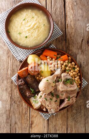 Madrid stew on a plate on a wooden table With bread and a glass of red ...