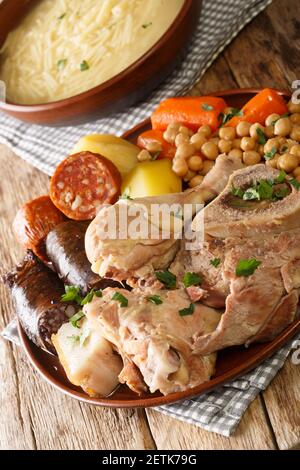 Traditional Spanish cocido madrileño in bowl on wooden table Stock ...