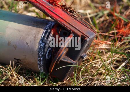 a discharged British Army red smoke grenade lying on mud and grass ...