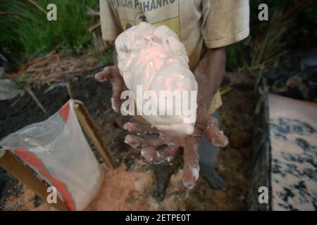 A man showing his sago creation on the side of Salawai river in Seram ...
