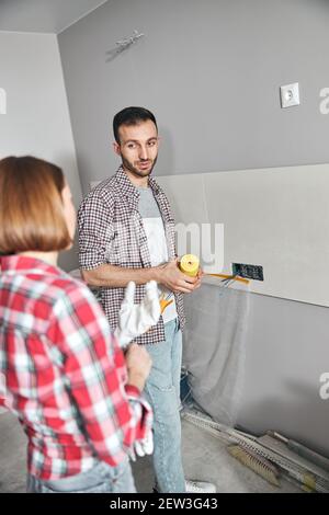 Getting ready to paint a wall Female painter decorator pulls on her ...