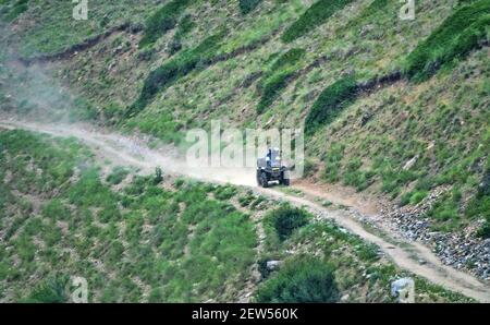 Buggy car (goes over all terrain) rides on a mountain road (alpine path ...