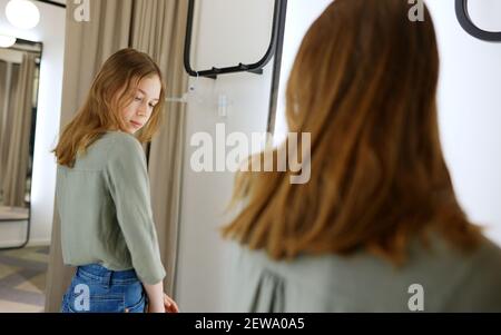 Tween girl standing in fitting room in clothing store Stock Photo - Alamy