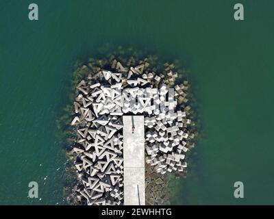 Aerial view of jetty with concrete blocks, white jetty against deep ...