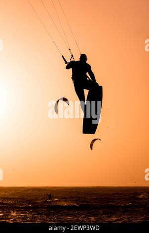 Man kiteboarder performing kitesurfing unhooked tricks, boy kitesurfer ...