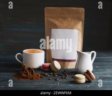 coffee beans, paper pack, macaroons and chocolate on wooden background ...