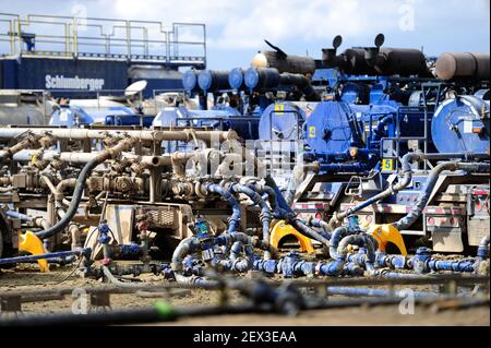 Schlumberger trucks with 2000 horsepower pumps direct water, sand and ...
