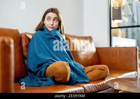 Frozen young woman with plaid on beige background, closeup Stock Photo ...