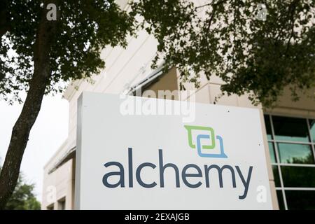 A logo sign outside of the headquarters of Alchemy Systems, LP, in ...