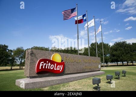A logo sign outside of the headquarters of Frito-Lay, Inc., a ...