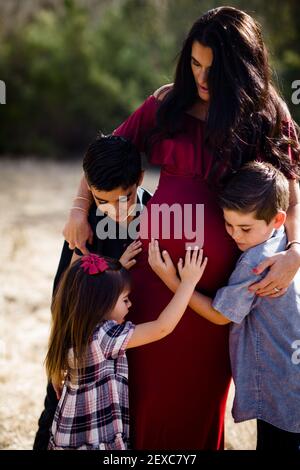 Children (2-3) hugging pregnant mother Stock Photo - Alamy