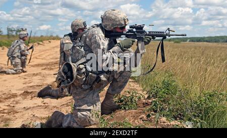 A Michigan Army National Guard soldier opens a map to plot his ...