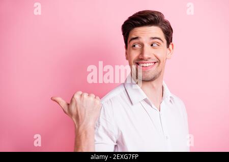 Portrait of optimistic nice guy point look empty space wear white shirt ...