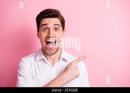 Portrait of optimistic funny guy point empty space wear yellow t-shirt ...