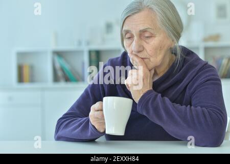 sad old woman with headache drinking tea Stock Photo - Alamy