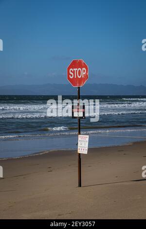 Sign post and footprints on deserted shore at Ventura Beach, California ...