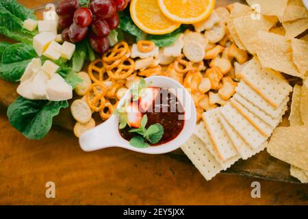 An assortment of yummy snacks: cheese, crackers, chips, fruits, and ...