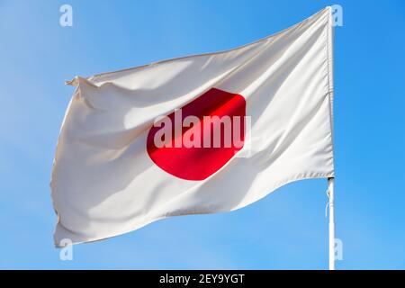 Japanb waving flag in the blue sky bcolour and wave Stock Photo - Alamy