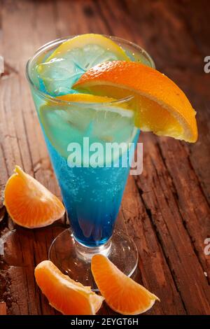 Glass with blue curacao cocktail, fresh mint and lemon, bar tools on ...