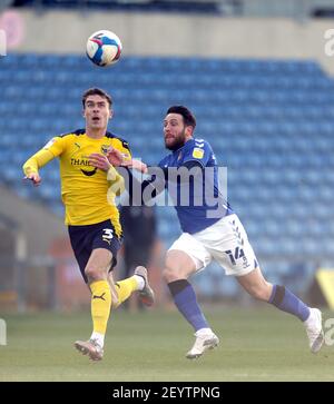 Oxford United's Josh Ruffels (right) gets his cross past AFC Wimbledon ...