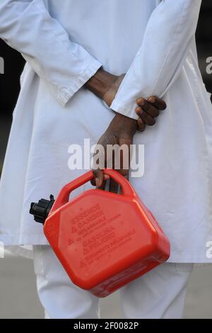 Man holding red canister on white background Stock Photo - Alamy