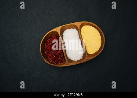 A black bowl filled with coarse white crystals sits on a blue wooden ...