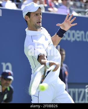 Conor Niland of Ireland returns a ball to Novak Djokovic of Serbia ...