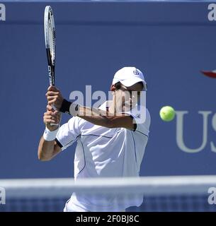 Conor Niland of Ireland returns a ball to Novak Djokovic of Serbia ...