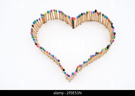 a heart shape made of multicolored matchsticks with heart-shaped ...