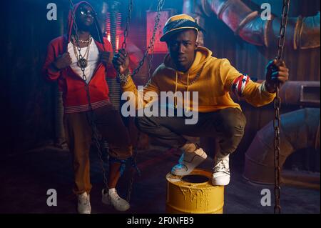 Two stylish rappers dancing in studio with cool underground decoration ...