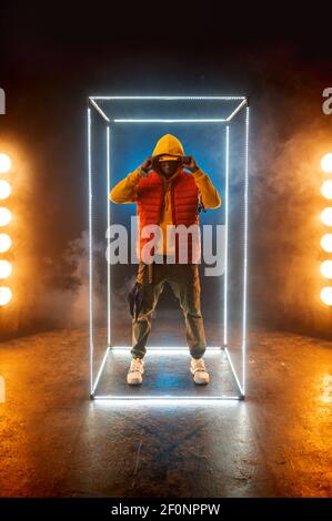 Young stylish rapper poses in studio with yellow tones. Hip-hop ...