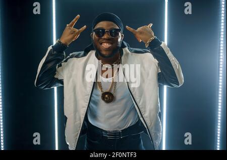 Smiling rapper on the stage with illuminated cube. Hip-hop performer ...