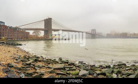 Brooklyn Bridge, rainy foggy day. New York City Manhattan downtown ...