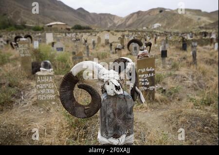 June 2008- Nokhur, Turkmenistan- Wild goat horns mark the graves at a ...