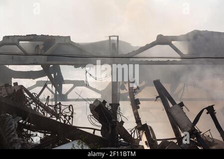 Technological disaster, fire, destroyed industrial building, smoke and ...