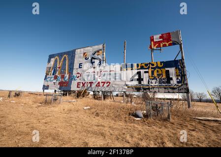 A tattered and weather-beaten billboard sign showing evidence of ...