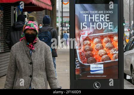 A woman walks past Lurpak's digital advert in London. (Photo by ...