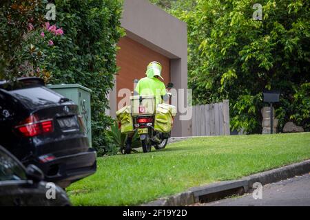 Australia Post mail delivery postman riding motorbike delivers mail to ...