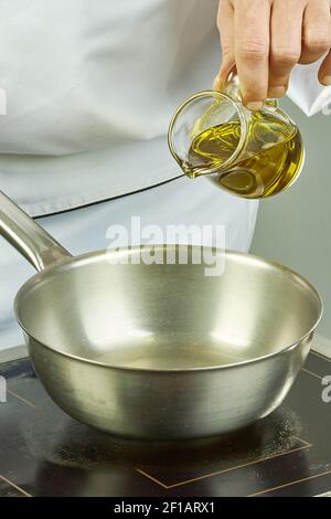 Chef pours oil into the pan for cooking series full cooking food ...